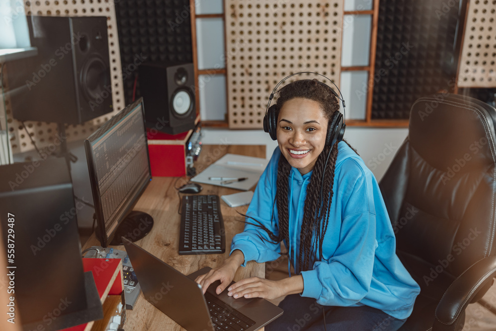 Beautiful woman sound engineer, radio presenter, smiles at camera while ...
