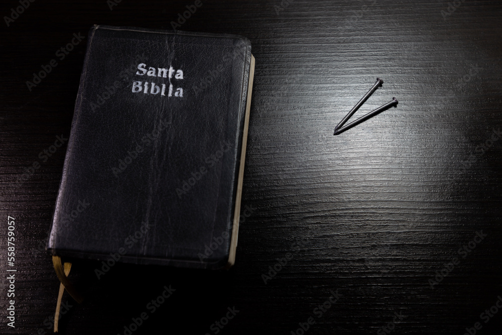 Portada de santa biblia en una meza y clavos oxidados formando una cruz ...