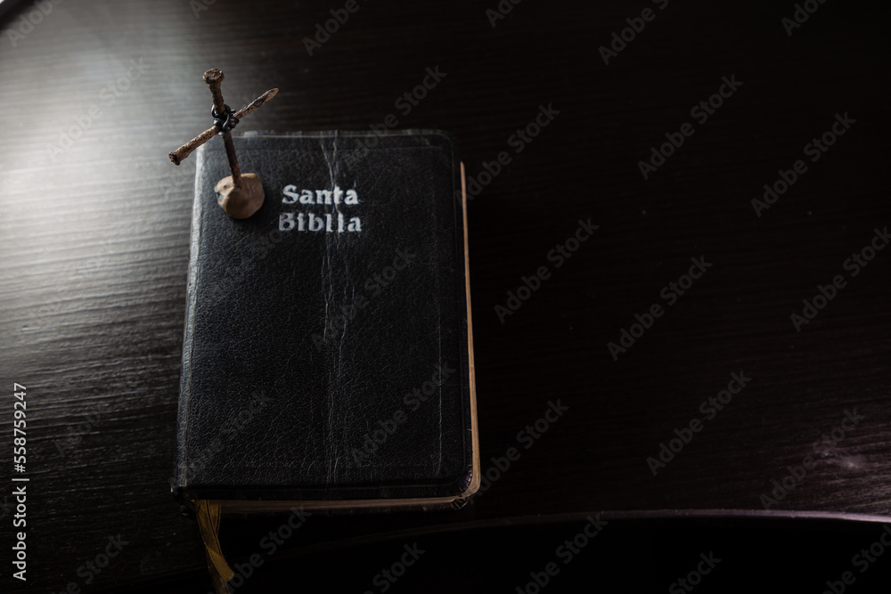 Portada de santa biblia en una meza y clavos oxidados formando una cruz ...