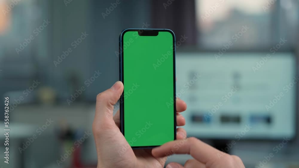 Man Sitting In Office Uses Smartphone With Green Screen Mock Up Display. Man Makes Gestures ...