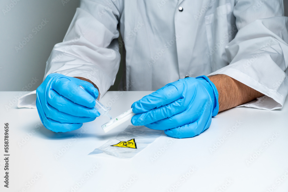 Nurse drops test liquid in rapid test cassette for detection of ...