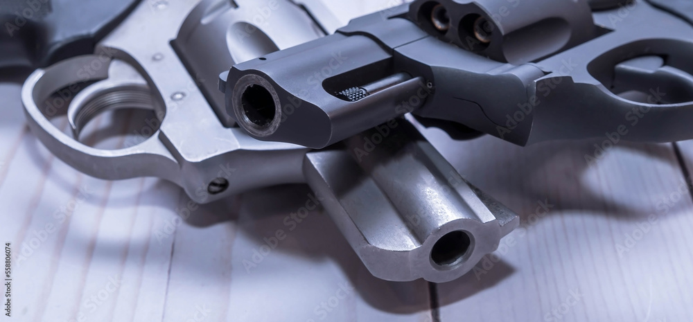Two snub nose revolvers, a black 38 special and a stainless 357 magnum ...