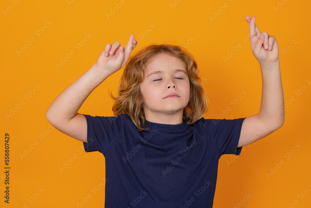 Child crossed fingerson yellow isolated studio background. Child closed ...