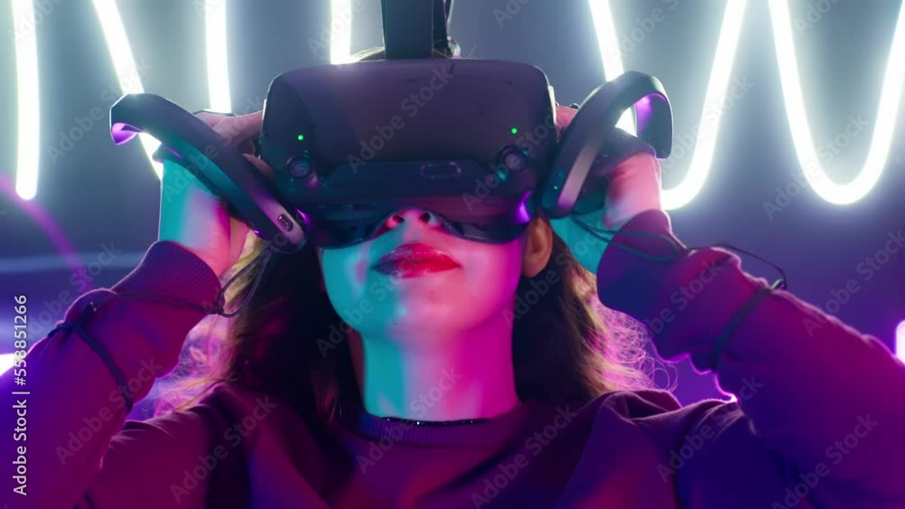 Cyber gamer in VR glasses plays virtual reality game in neon futuristic ...