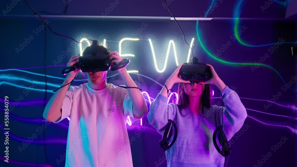 Cyber gamer in VR glasses plays virtual reality game in neon futuristic ...