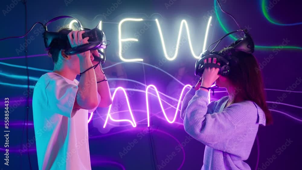 Cyber gamer in VR glasses plays virtual reality game in neon futuristic ...