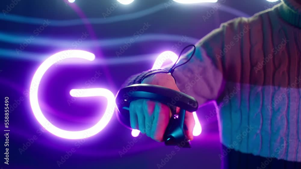 Cyber gamer in VR glasses plays virtual reality game in neon futuristic ...