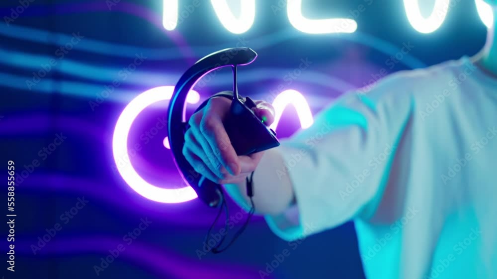 Cyber gamer in VR glasses plays virtual reality game in neon futuristic ...