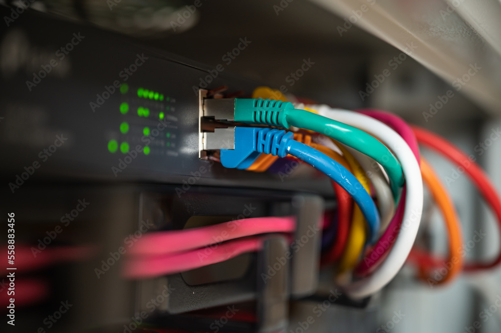 Patch panel and switch with colorful LAN cables in a network cabinet of ...