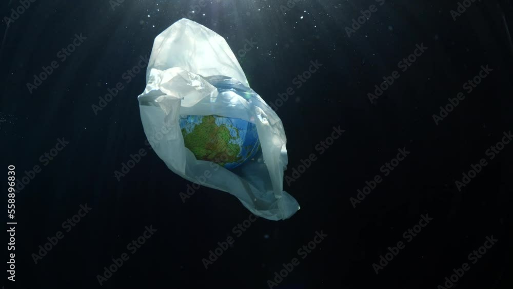 world in plastic bag drifting underwater representing ocean pollution ...