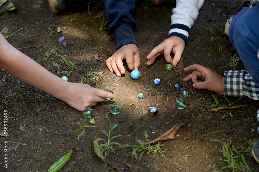 Boy playing with marbles on the sidewalk. retro game, having fun with ...