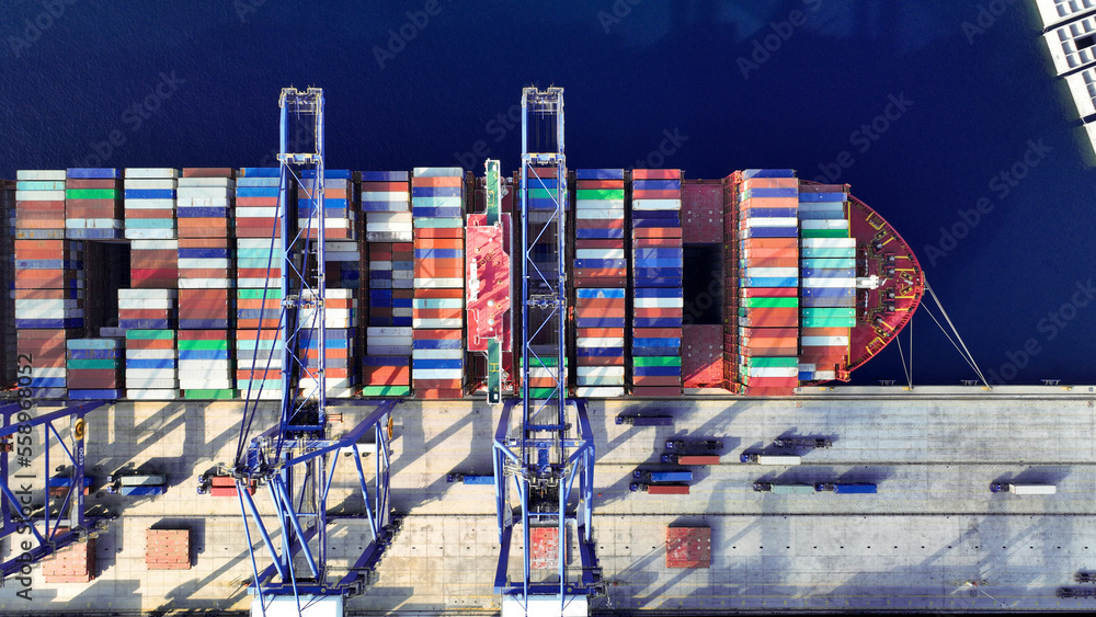 Aerial top down photo of industrial cargo container ship being loaded ...