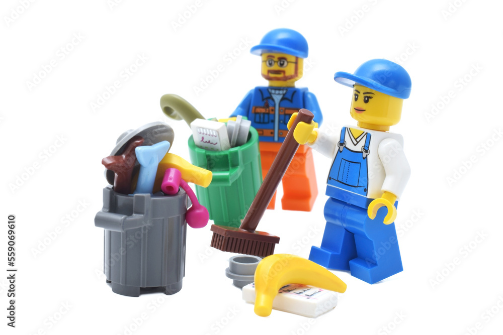Lego minifigure of cleaning service is removing a garbage in trash cans ...