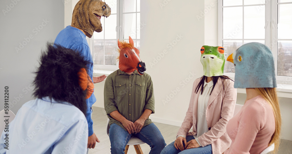 Group of funny people in animal disguise having a meeting in the office ...