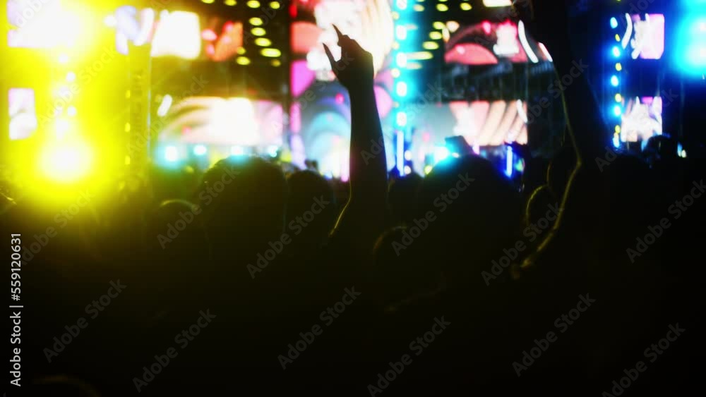 People jump and dance at the evening concert with light show.Fans raise ...
