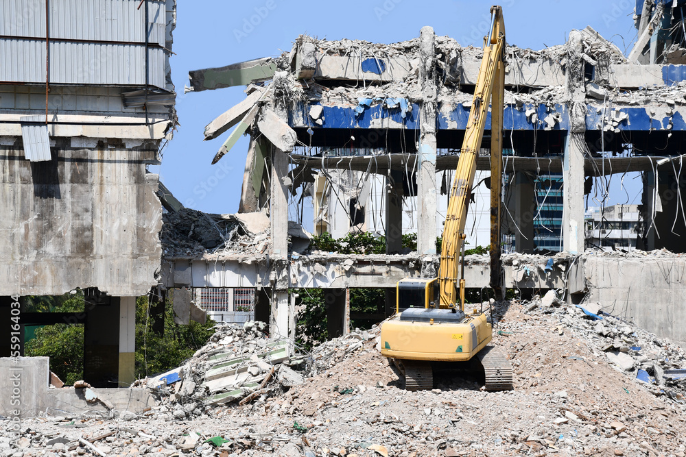 Building demolition, Backhoe excavator and truck clearing wreckage ...