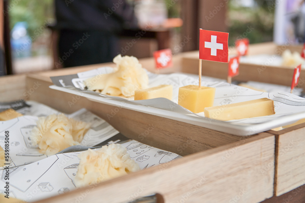 tray with mix of swiss cheeses and switzerland flag. Gruyere, emmental ...