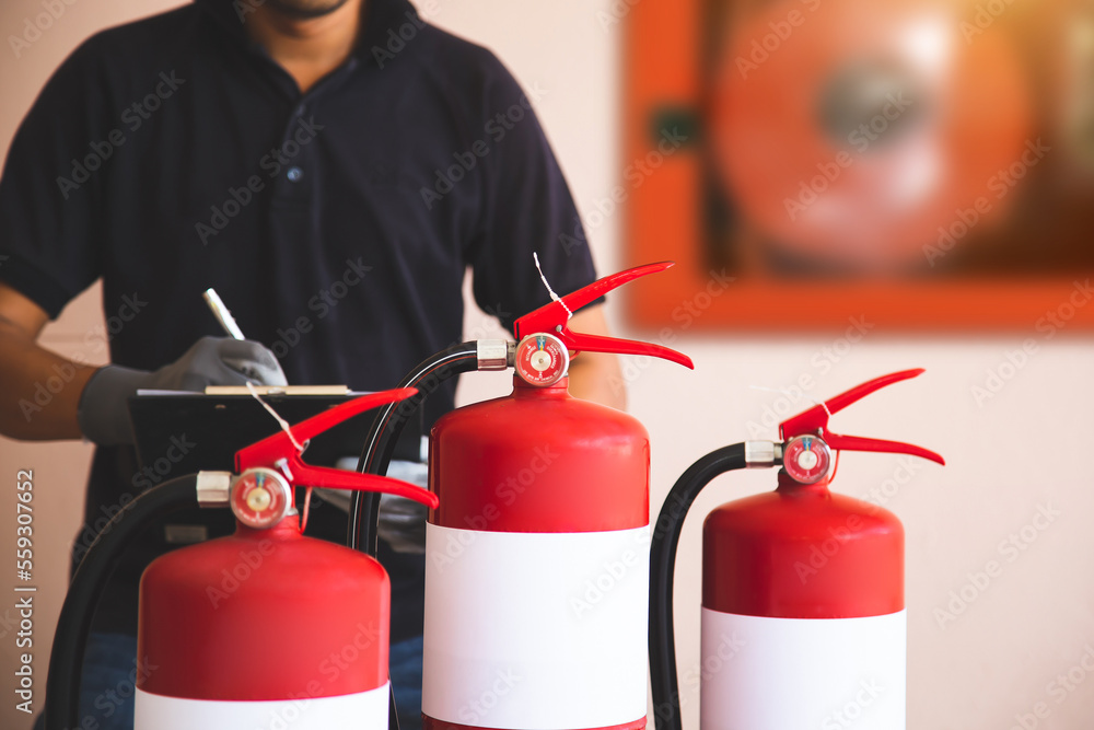 Close up fire extinguisher and firefighter checking pressure gauge ...