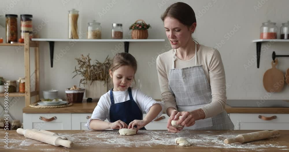 Loving mother teach little pretty daughter to cook, preparing together ...