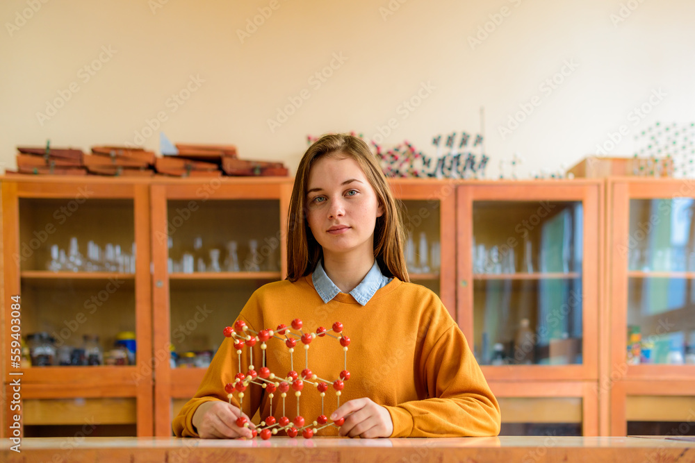 Female student holding molecular structure model. Science class concept ...