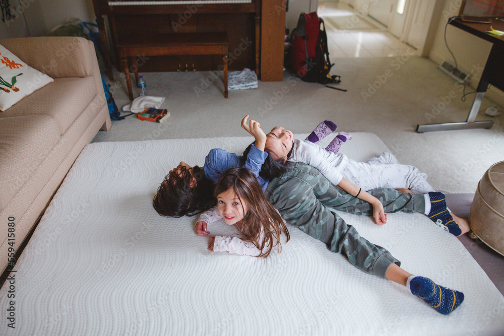a small group of children playing and wrestling on the floor laughing ...