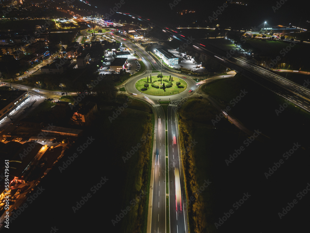 night view of a road busy with cars regulated by a roundabout. the slow ...