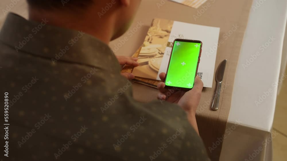 Caucasian man scanning qr code with smartphone with chroma green screen ...