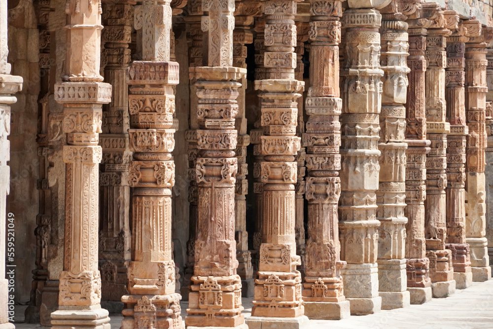 Row of pillars with bas relief carvings in the complex of Qutb Minar ...