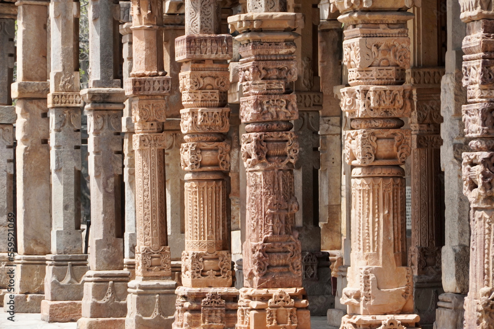 Row of pillars with bas relief carvings in the complex of Qutb Minar ...