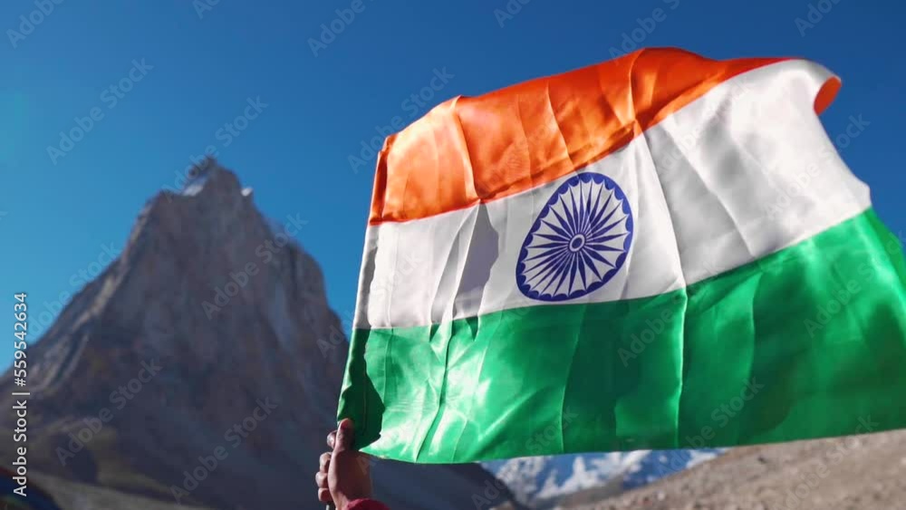 Close up shot of man holding Indian flag in background of Gumbok Rangan ...