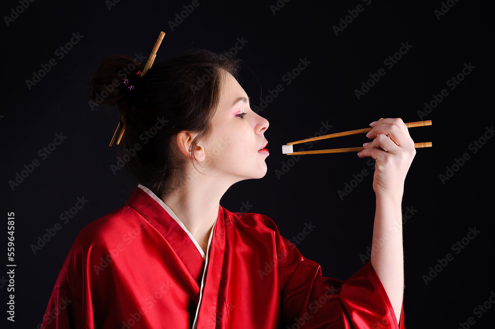 The girl in native costume of japanese geisha, isolated on black Stock ...