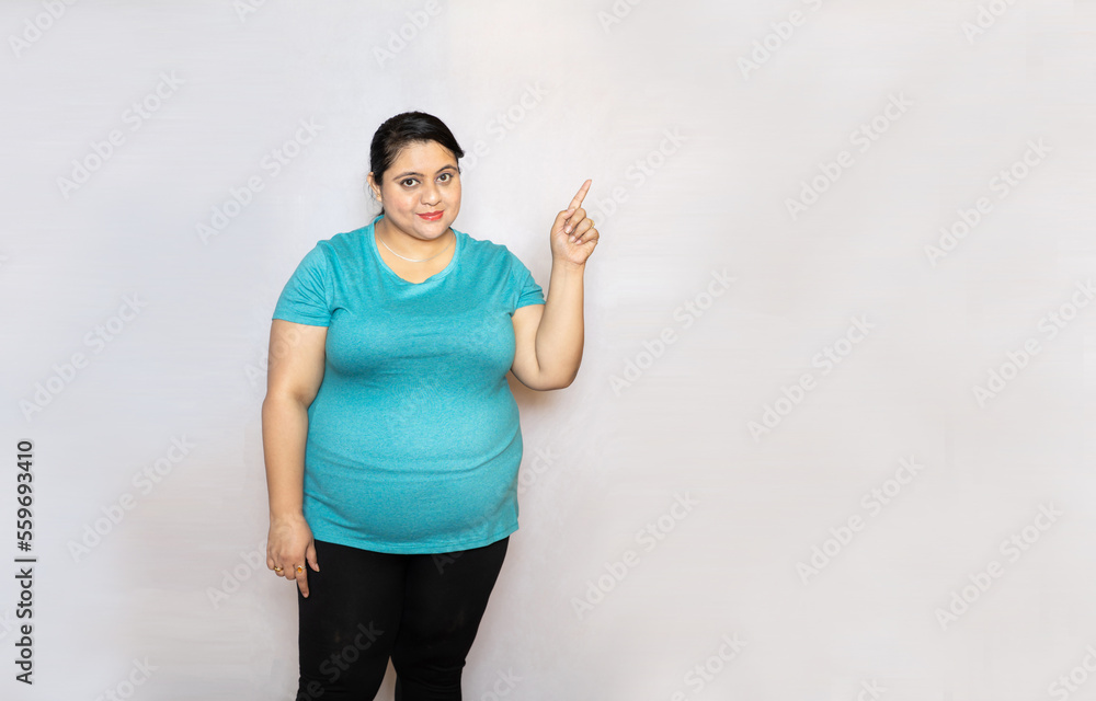 Overweight fat indian woman standing pointing at copy space or free ...