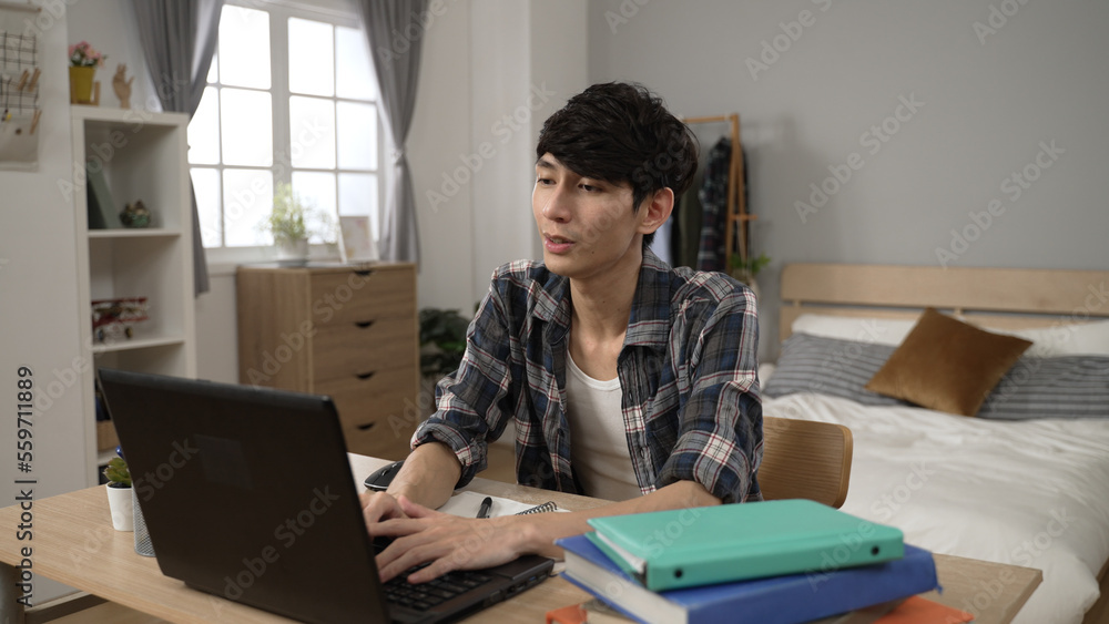 happy Asian male korean student learning from home on the laptop in ...
