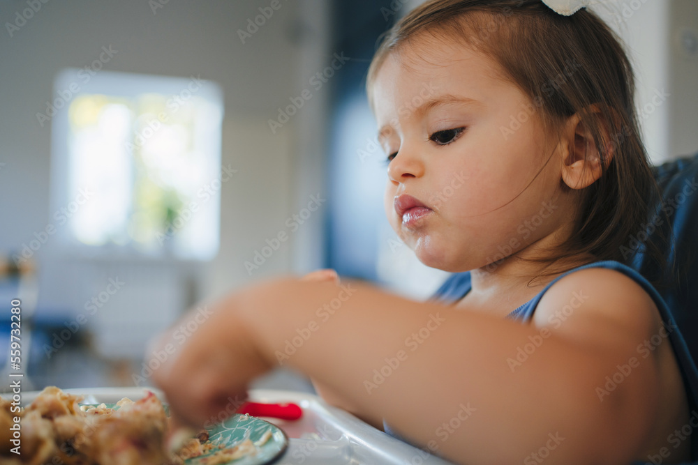 Happy baby girl eating with finger solid food. Baby led weaning self ...