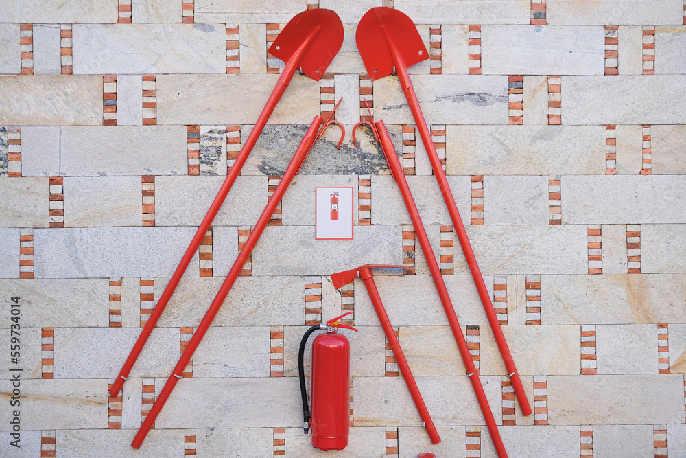 Fire fighting kit on building wall, fire extinguisher, shovels and ...