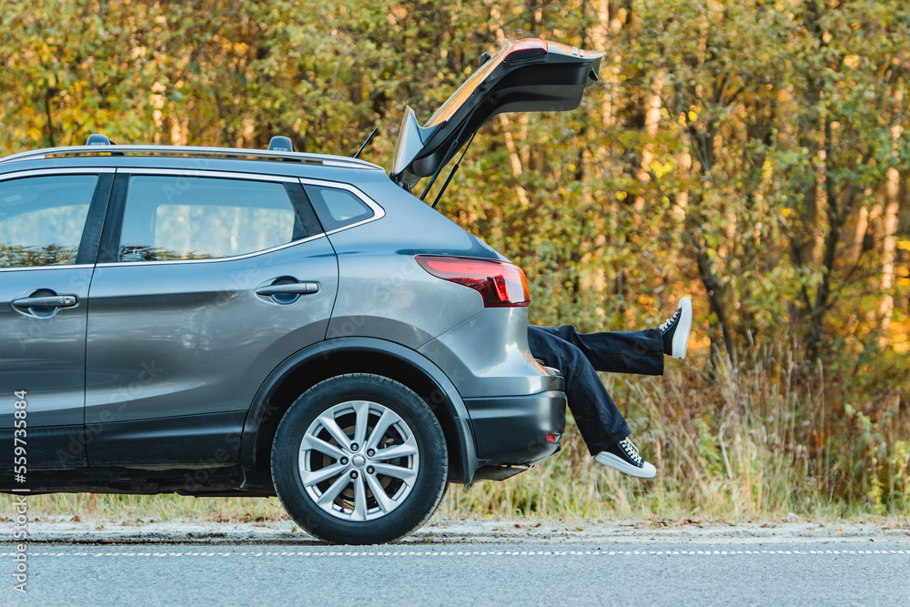 women's legs sticking out of the trunk of a car. stop for the rest ...