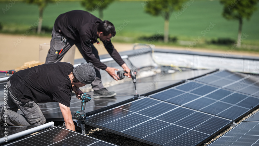 Male team engineers installing stand-alone solar photovoltaic panel ...