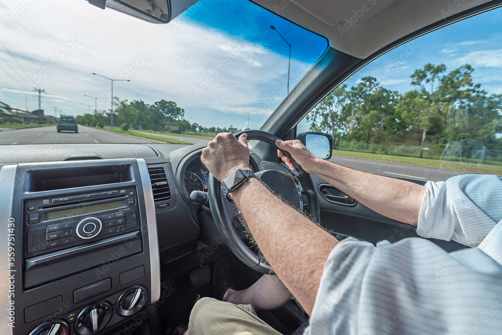 Hands on wheel driving car down road Stock Photo | Adobe Stock