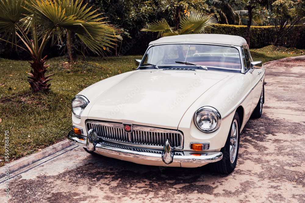 Classic MG MGB Roadster GT cream color car parked on road in garden ...