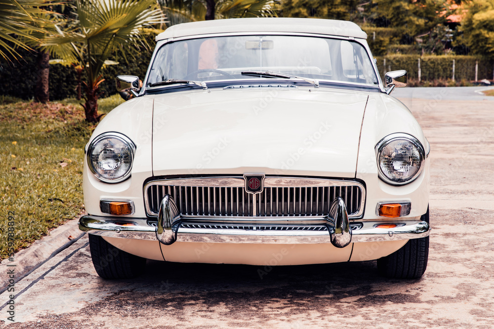 Classic MG MGB Roadster GT cream color car parked on road in garden ...