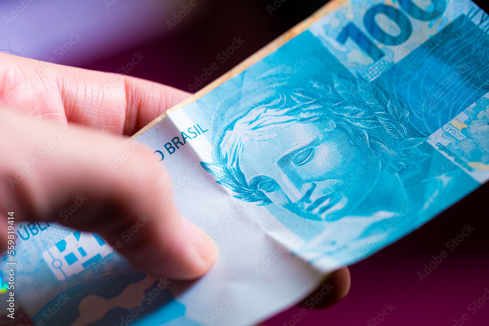 Foto de Um homem segurando notas do Real Brasileiro em sua mão ...