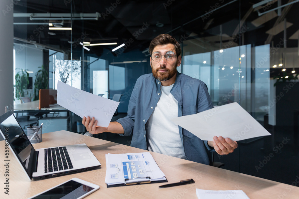 Dissatisfied and angry businessman inside office showing reports and ...