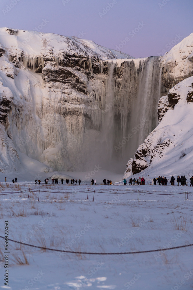 imagen de la cascada de Skógafoss con el entorno nevado, y una capa de ...