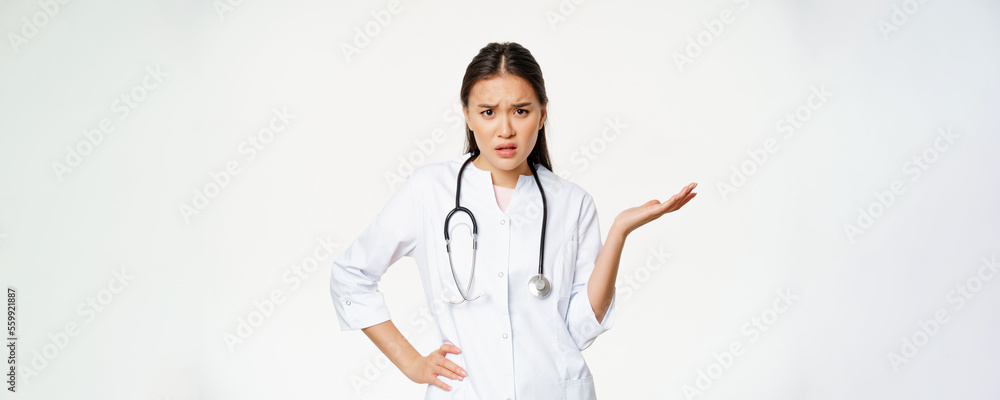 Confused asian woman doctor cant understand patient, looking puzzled ...