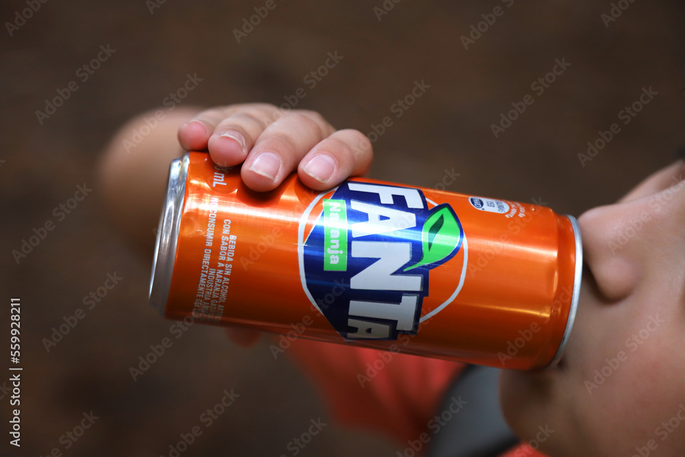 Child having a soda. Boy drinking Fanta orange from a soda can ...