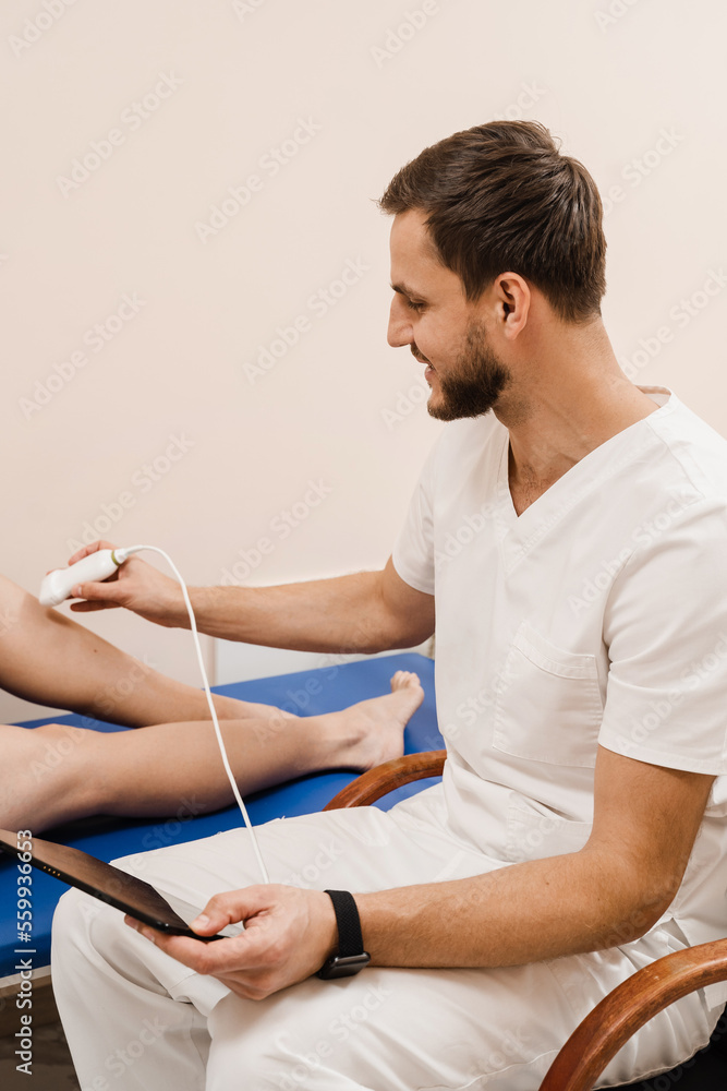 Vascular surgeon examines arteries and veins of legs using portable ...