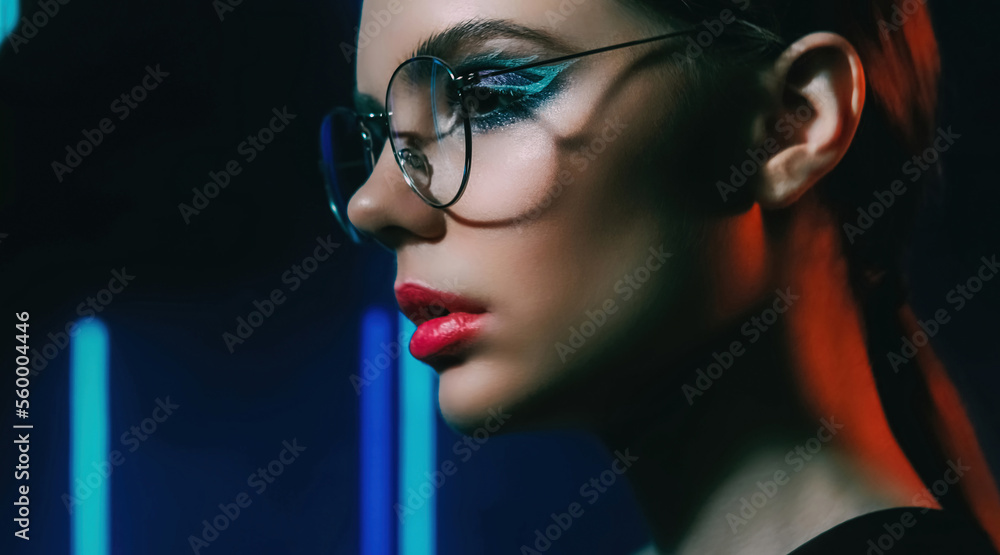 Retro look. Eyewear fashion. 2000s beauty. Blue color neon light closeup profile portrait of ...