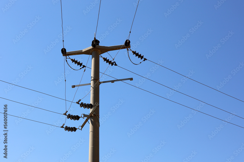 Power line post with electrical wires and capacitors on blue sky ...