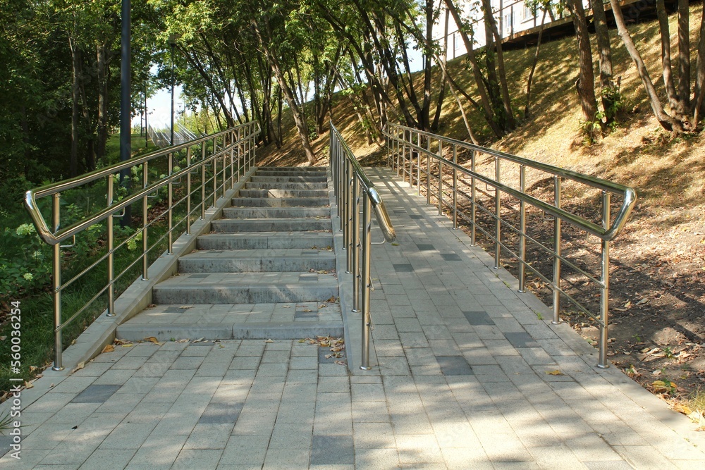 Stairs and ramp with metal railings for the passage of strollers and ...