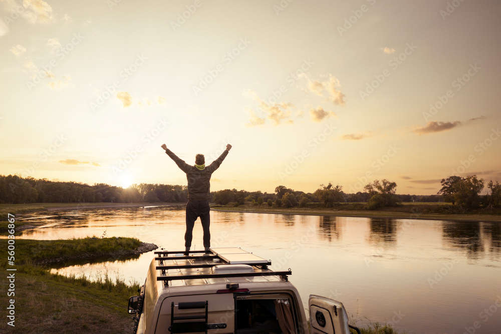 Happy person standing on top of a camper van in nature Stock Photo ...